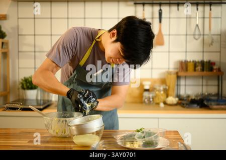 Man squeezing freshly churned butter, separating buttermilk into bowl ...
