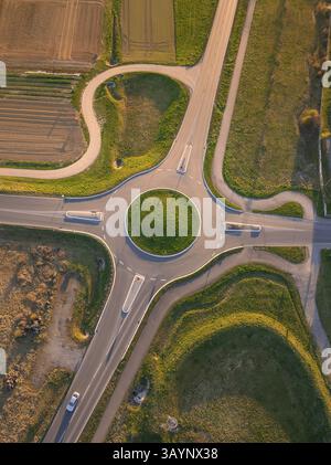 An aerial view of a road surrounded by fields and ponds under the ...