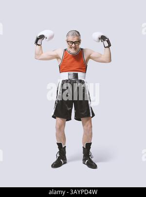 Funny aggressive skinny boxer showing off his muscles and looking at ...