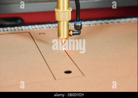 Precision laser cutting shapes cardboard sheets in a modern ...