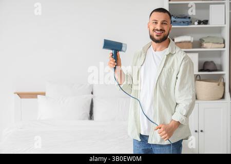 Young man with steamer in bedroom Stock Photo - Alamy
