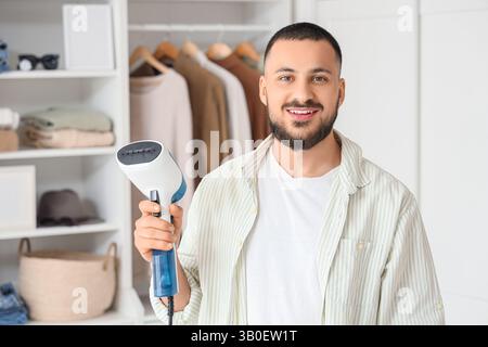 Young man with steamer in bedroom Stock Photo - Alamy