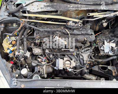 Burned car engine block and wiring with melted plastic covers, charred ...