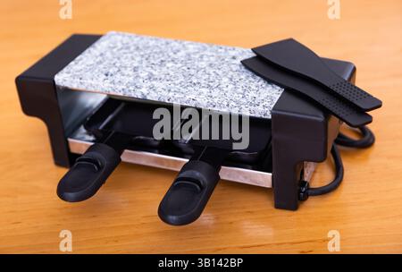 Table-top grill involved in serving swiss dish of raclette Stock Photo ...
