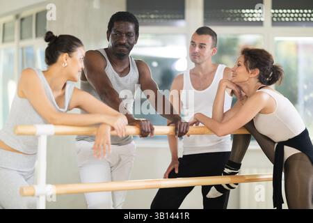 Group of dancers talking at ballet barre Stock Photo - Alamy