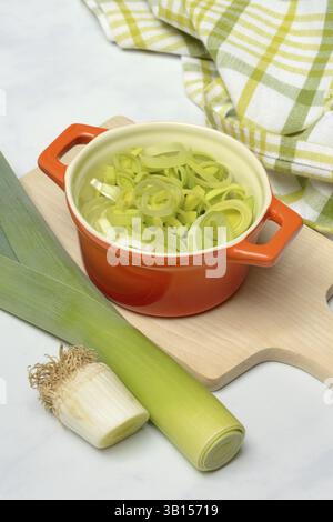 sliced Leek vegetable in wooden bowl isolated on white background. Top ...