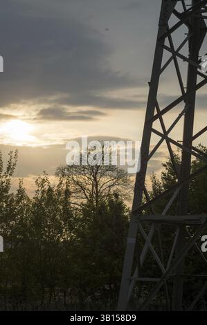 crossing electric pylon in sunset sky Stock Photo - Alamy
