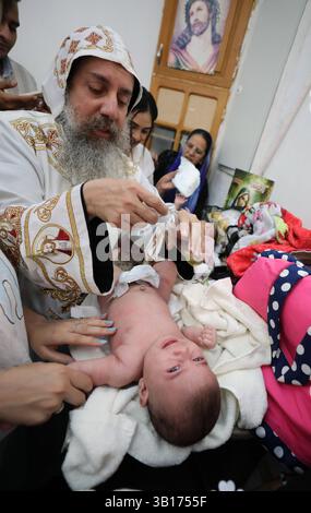 Mass baptism ceremony in Egypt A baby is baptized during a mass baptism ...