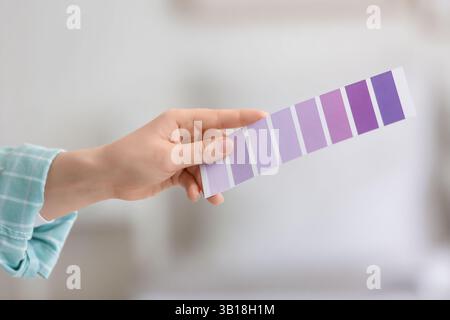 Female hand with violet paint palette swatches at home, closeup Stock ...