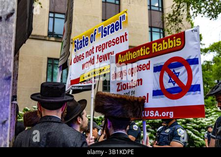 Protesters hold signs denouncing the U.S. military operation against ...