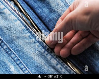 A person unzipping a blue jacket Stock Photo - Alamy