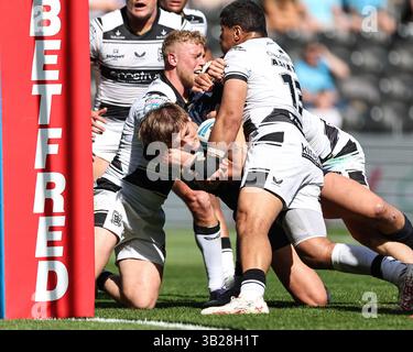 Harvey Makin of Wigan Warriors is tackled by Kaide Ellis of Wigan ...