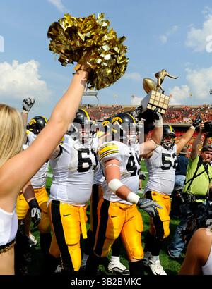 Iowa State players celebrate with the Cy-Hawk trophy after an NCAA ...