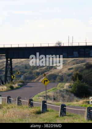 Curved Road Beneath Railway Bridge - A quiet rural road winds under a ...