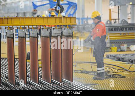 A worker washes plates with cathode copper at an industrial plant Stock ...