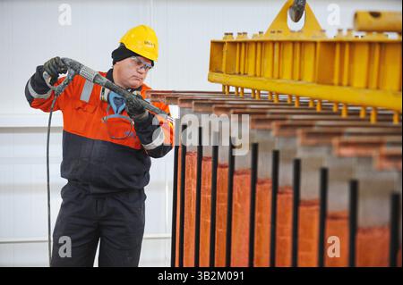 A worker washes plates with cathode copper at an industrial plant Stock ...
