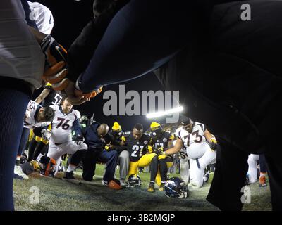 Players from both teams pray after an NFL football game between the ...
