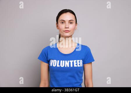 Young beautiful woman wearing volunteer t shirt at donations stand ...