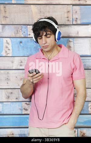 Young arab man listening to music sitting on sofa at home Stock Photo ...