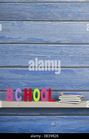 School in colorful letters and notebooks with vintage blue wooden wall ...