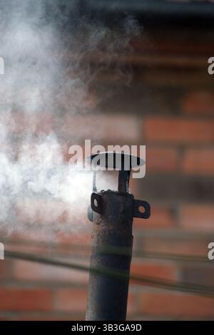 Smoke from the chimney. Outdoor kitchen. Steel pipe. Thick smoke from a ...