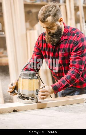 Worker uses tools on wooden beams joins structure they stand on ladder ...