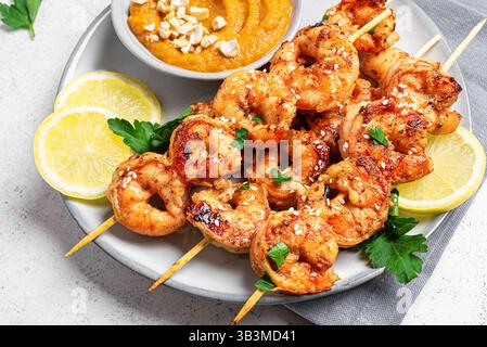 Grilled shimp prawn satay with spicy peanut sauce on dark concrete ...