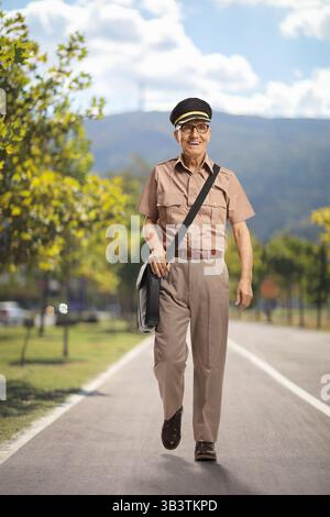 Full length shot of a mature mailman in a uniform carrying a bag and ...