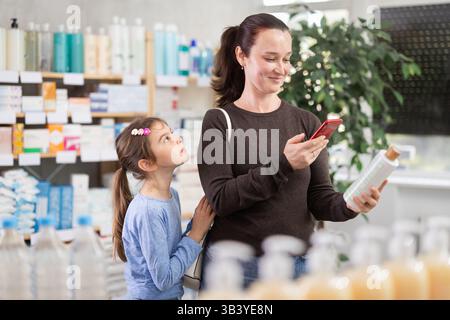 Woman scanning barcode on shampoo bottle Stock Photo - Alamy