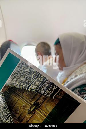 An elderly man in ihram and an elderly woman are flying in a plane for ...