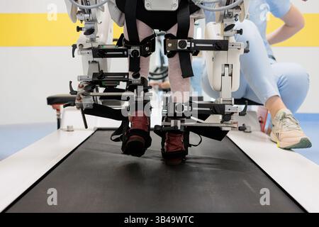 A child is walking with robotic legs on a treadmill in a gym Stock ...