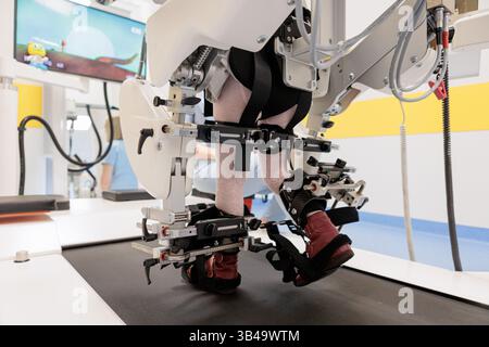A child is walking with robotic legs on a treadmill in a gym Stock ...
