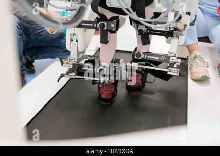 A child is walking with robotic legs on a treadmill in a gym Stock ...