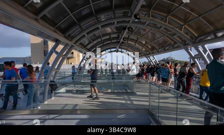 People standing along a covered deck on a ship going through the Panama ...