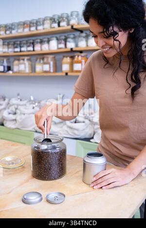 Young latin shopkeeper woman smiling happy holding gift at clothing ...