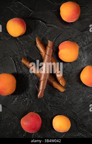 Pastila fruit skin rolls with fruits on a black background. Vegetarian ...