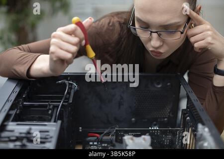A girl holds a screwdriver in her hand on a blue background Stock Photo ...