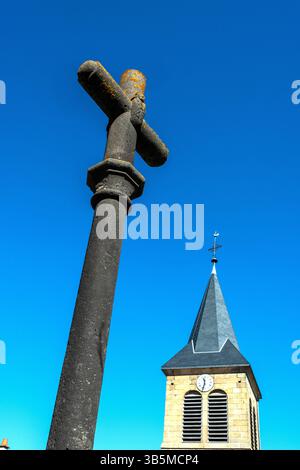 A historic stone church tower rises above medieval walls and terracotta ...