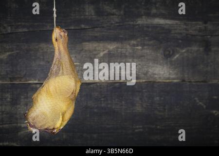 Smoked Chicken Leg Hanging on the Rope Against Wooden Background Stock ...