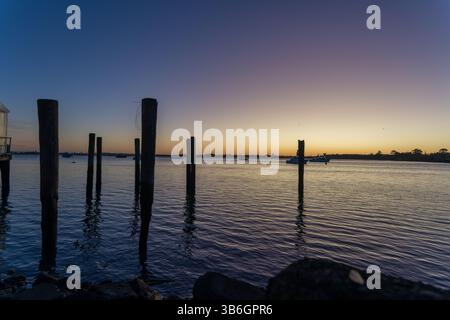 Old mooring posts in Tauranga harbour in pre-dawn light Stock Photo - Alamy