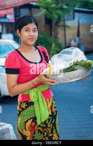 Bali, Indonesia - December 12, 2023: Woman in yellow offering prayers ...