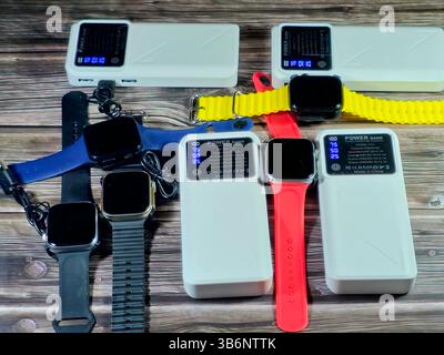 Modern power bank, smartwatch and mobile phone on green background ...