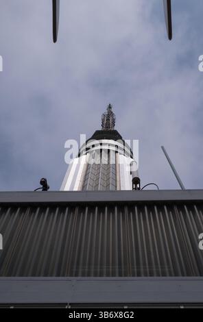Empire State Building spire and antennas against blue sky, viewed from ...