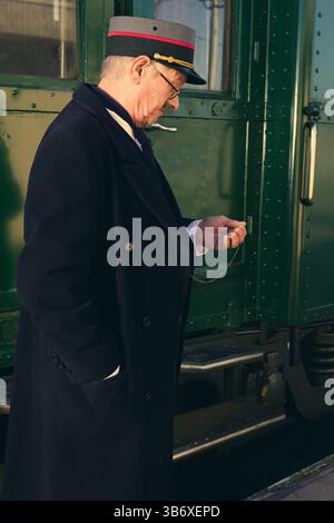 Reenactment scene of a vintage railway conductor at the departure of ...