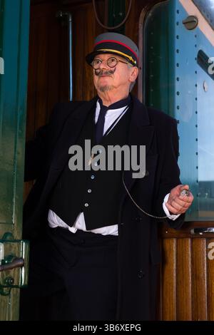 Reenactment scene of a vintage railway conductor at the departure of ...