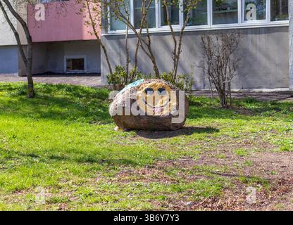 Smiley face painted in the large stone outdoors Stock Photo - Alamy