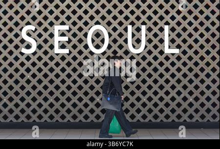 A person passes through a place where Seoul is written in English ...