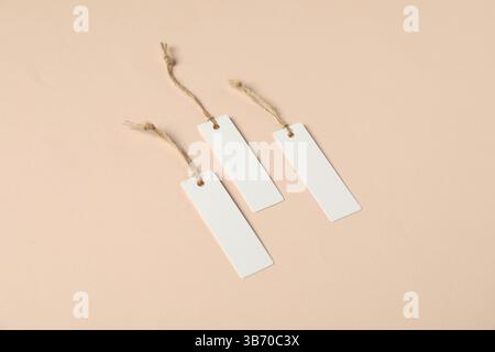 Blank tags with strings on beige background, flat lay Stock Photo - Alamy