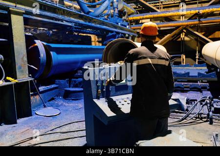 Factory engineer operates pipe painting automatic machine Stock Photo ...