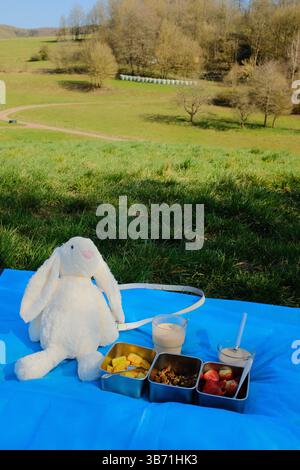 White plush rabbit toy sitting alone on bench during winter. Forgotten ...